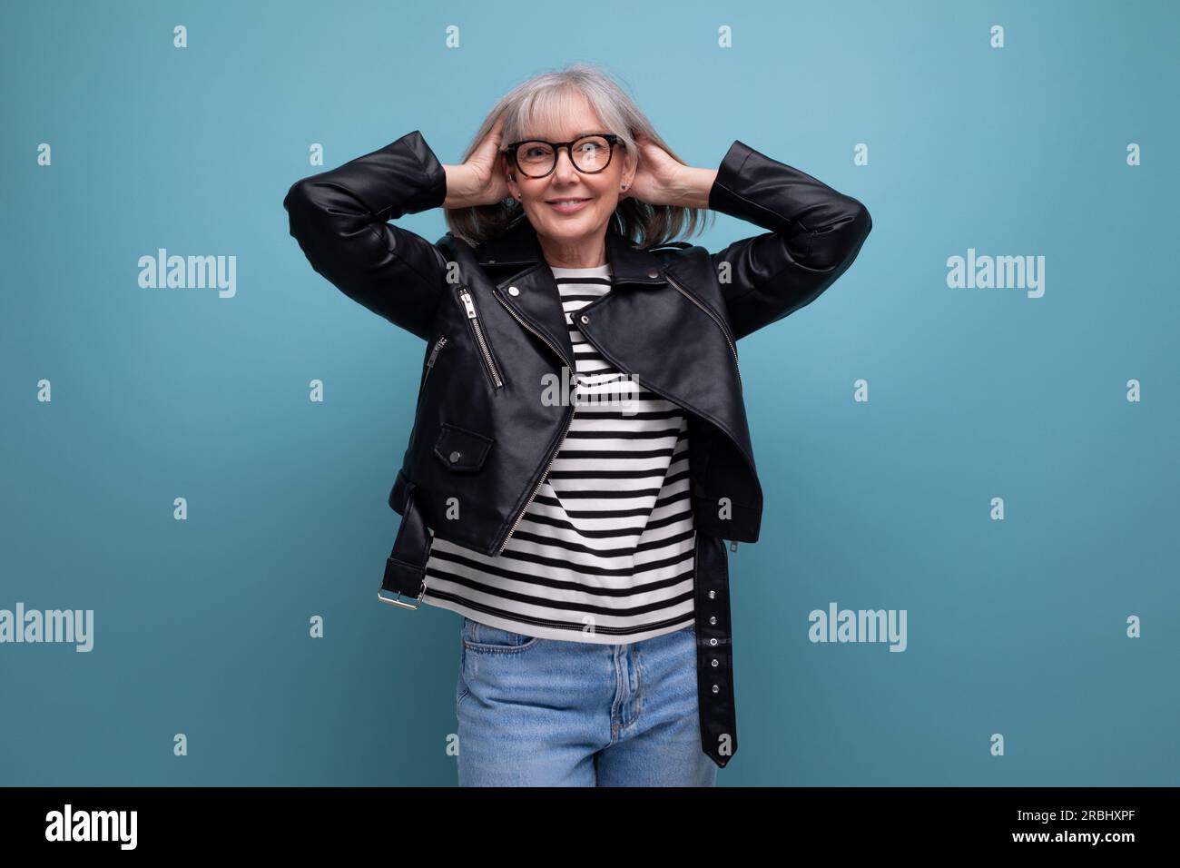 mature old woman in a stylish rocker jacket on a bright background ...
