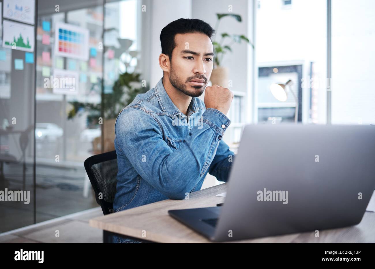 Thinking, laptop and man at desk reading email, website or research ...
