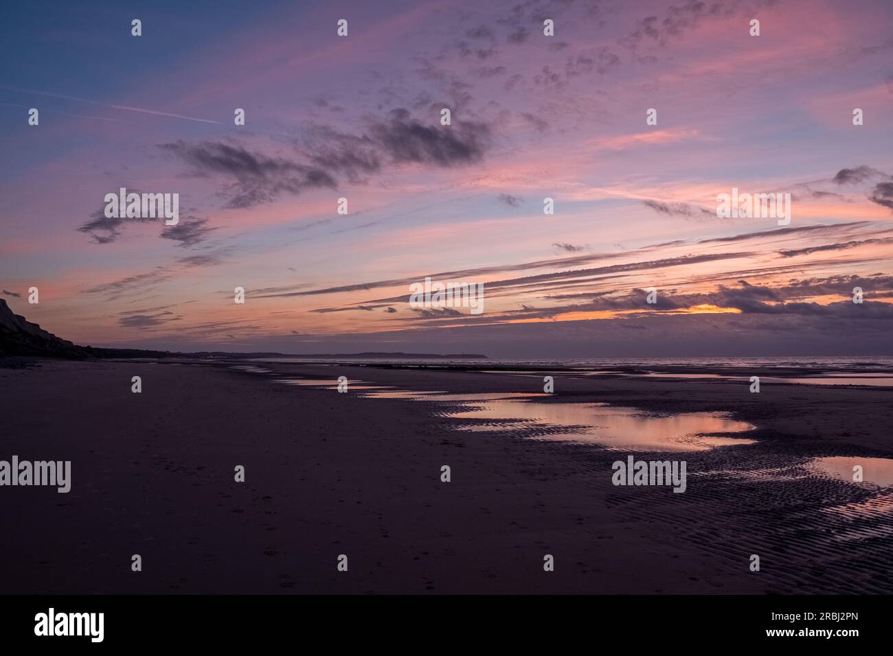 A magnificent capture of a dramatic sunset sky mirrored in the sandy ...