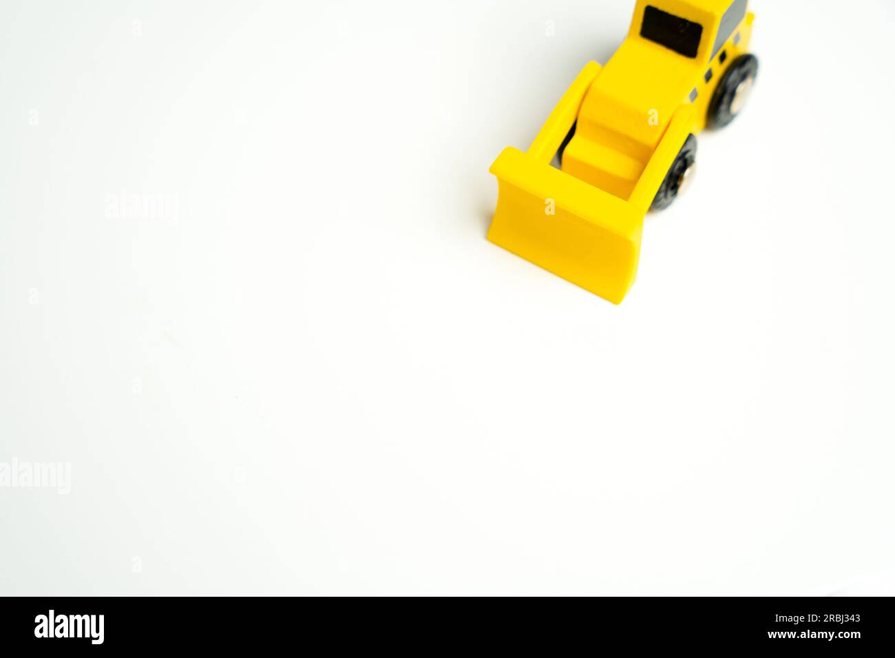 Toy yellow bulldozer and place for text on a white background ...