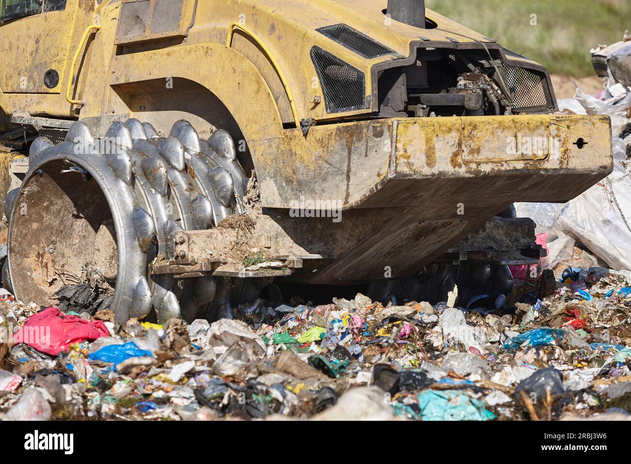 Heavy machinery shredding garbage in an open air landfill. Waste Stock ...