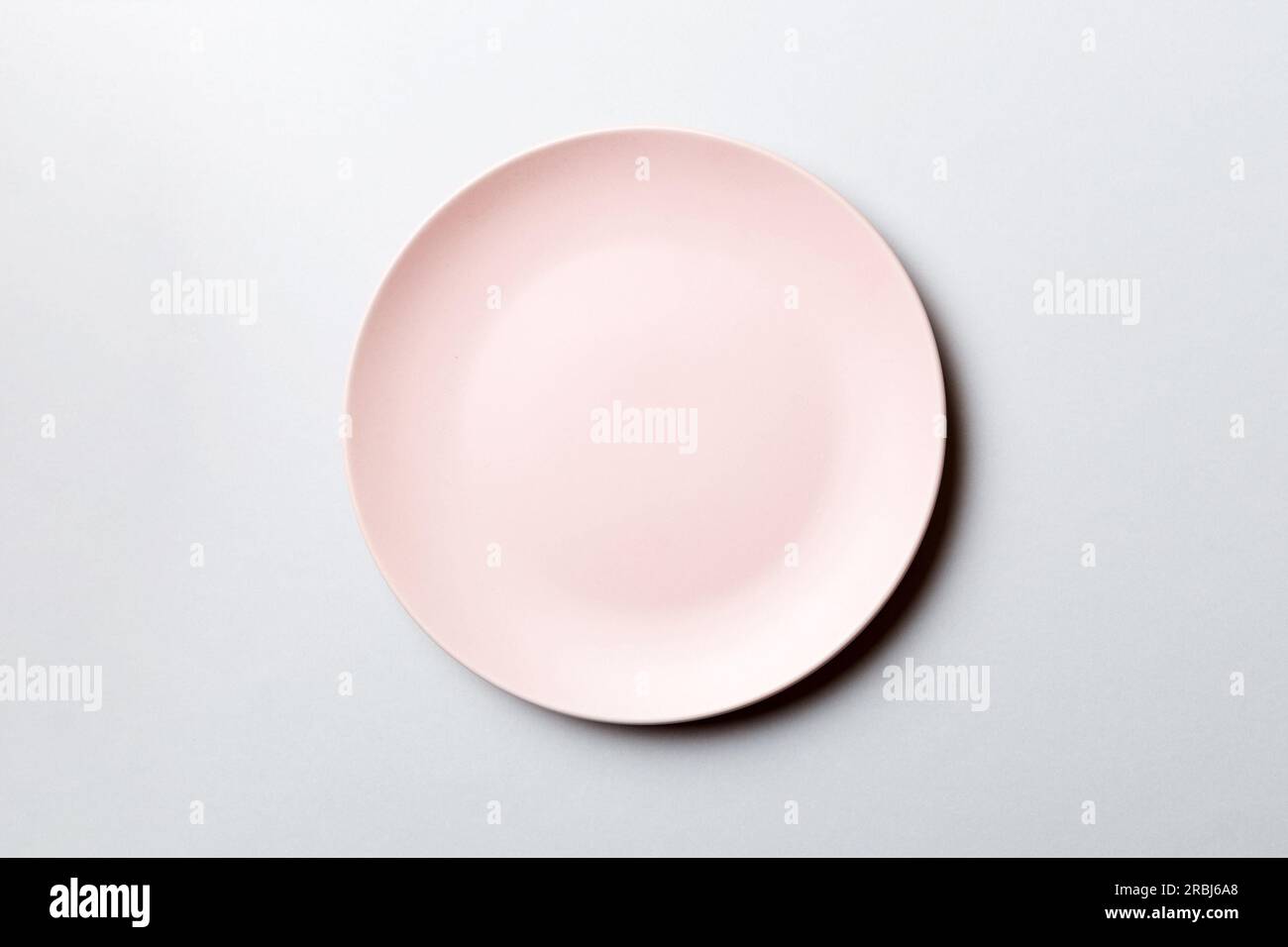 Top view of isolated of colored background empty round pink plate for ...
