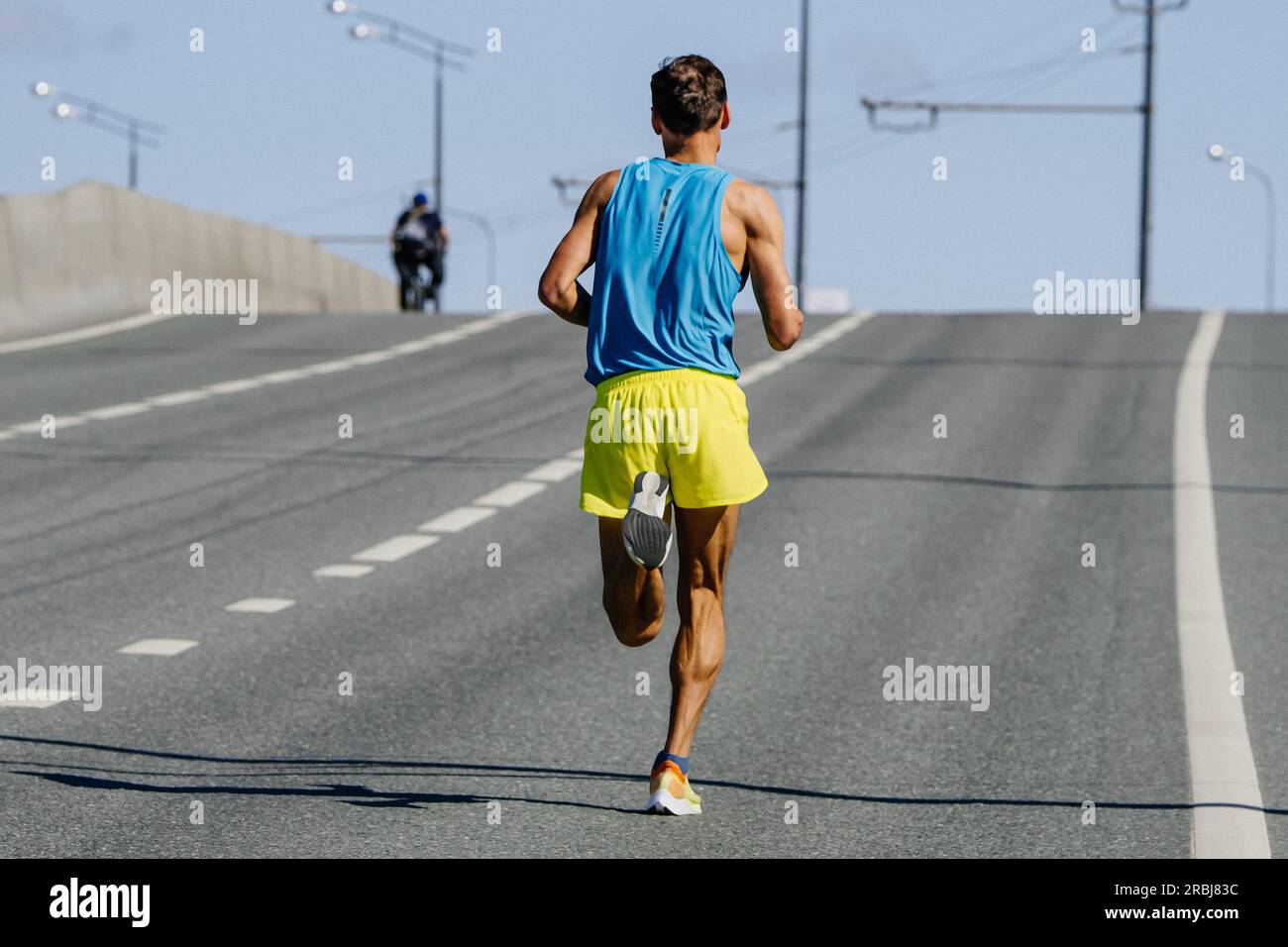 rear view male athlete running marathon race on road with marking line ...