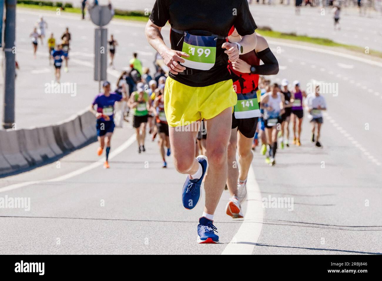 leading athlete runner running at head of large group runners marathon ...
