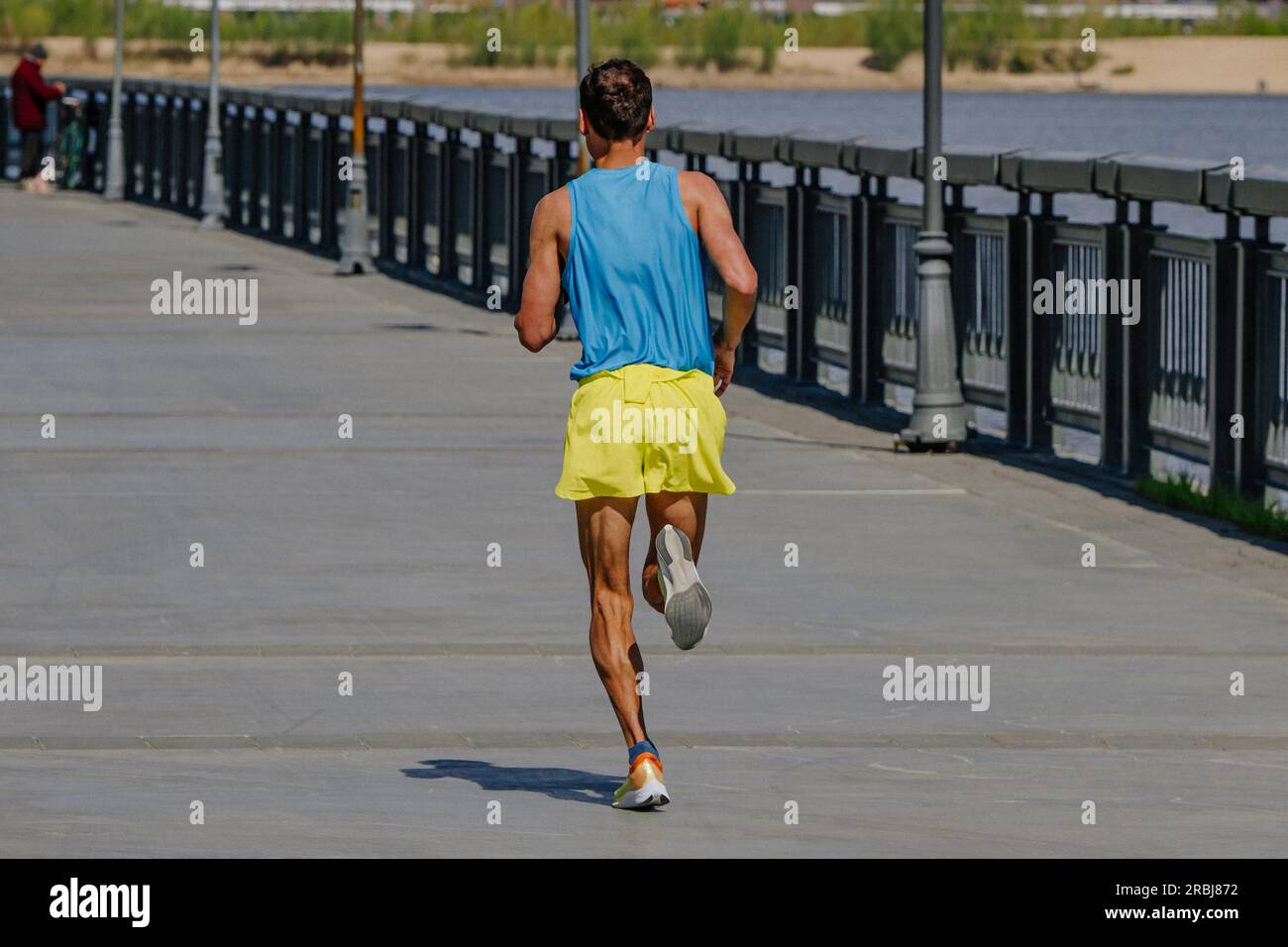 rear view athlete runner running marathon race in river embankment ...