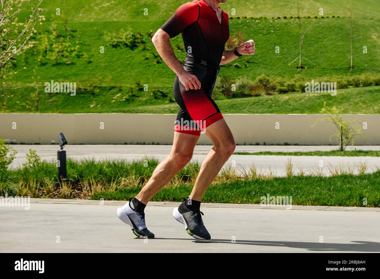 side view athlete runner running marathon race in urban landscape park ...
