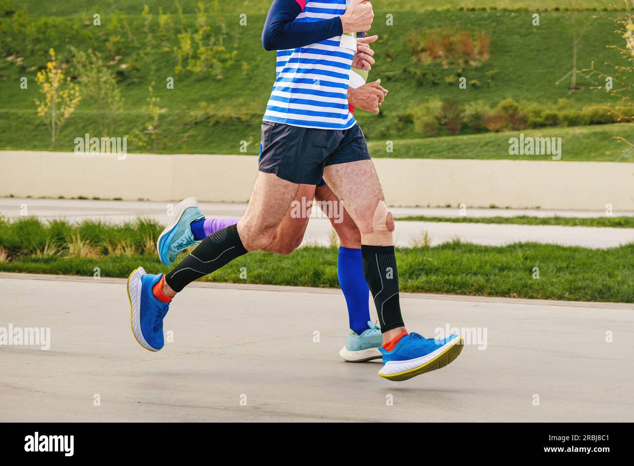 two male athletes runners running together marathon race in landscape ...