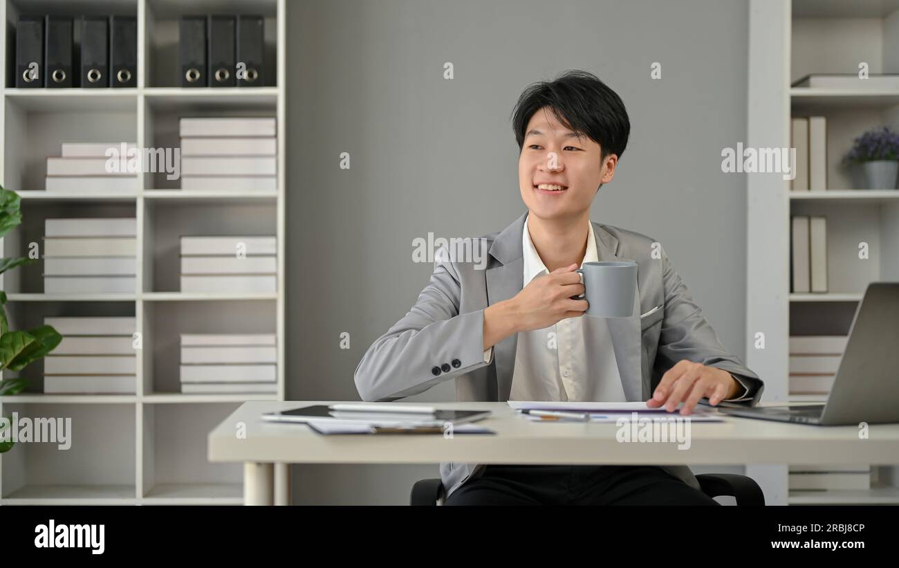 A happy and successful Asian businessman or male CEO in a formal ...