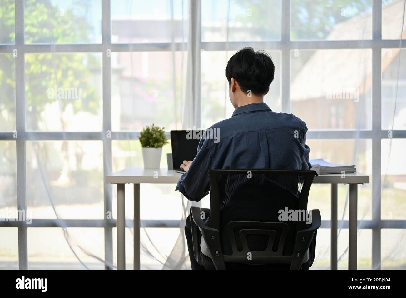 Back view image of a focused Asian businessman working on his work on ...