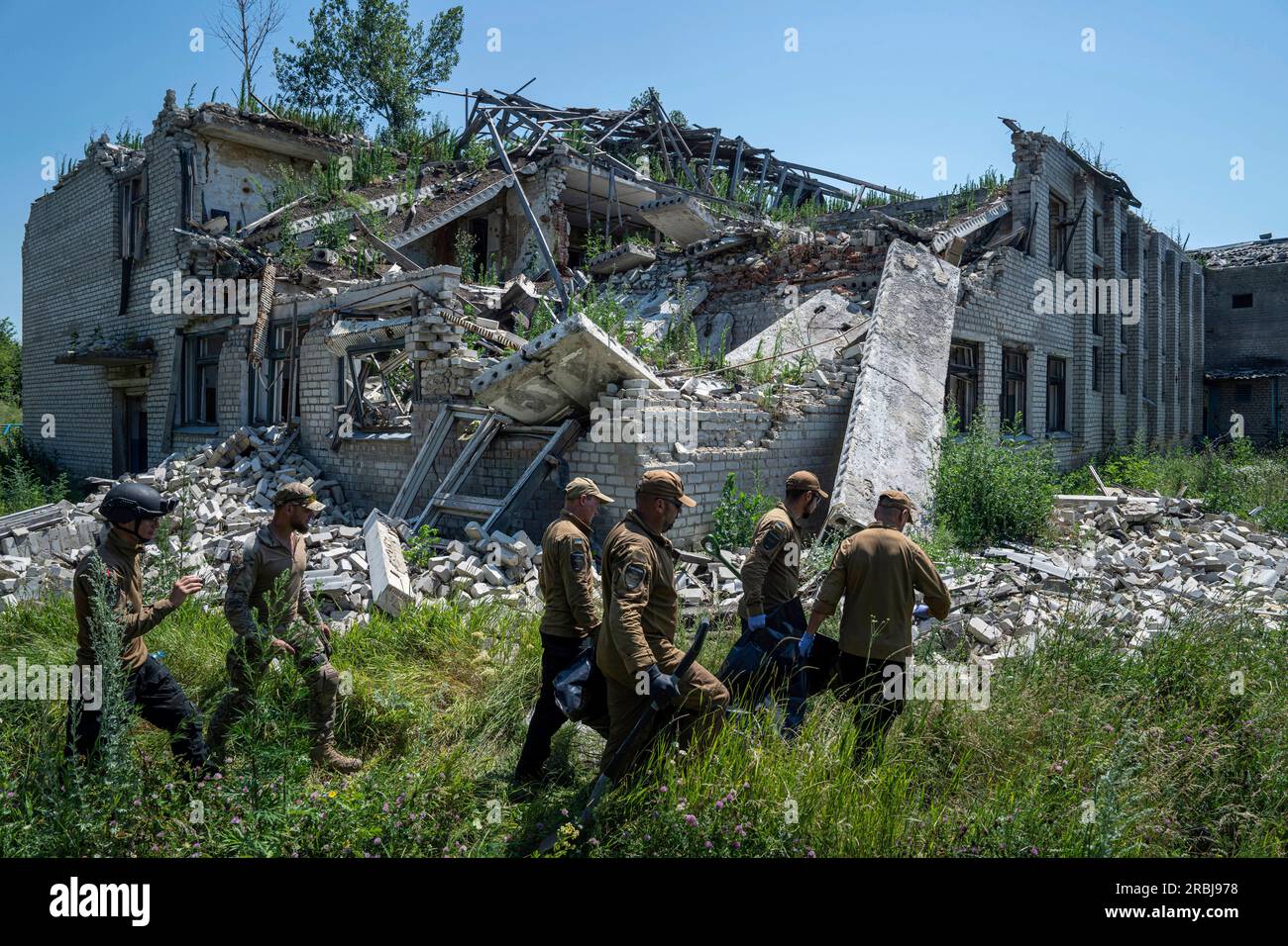 Body collectors carry the body of killed Russian soldier that was ...