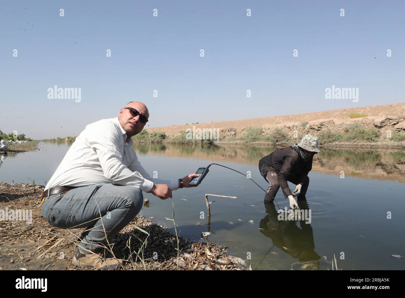 An employee of Iraq's Ministry of Water Resources measures the oxygen ...