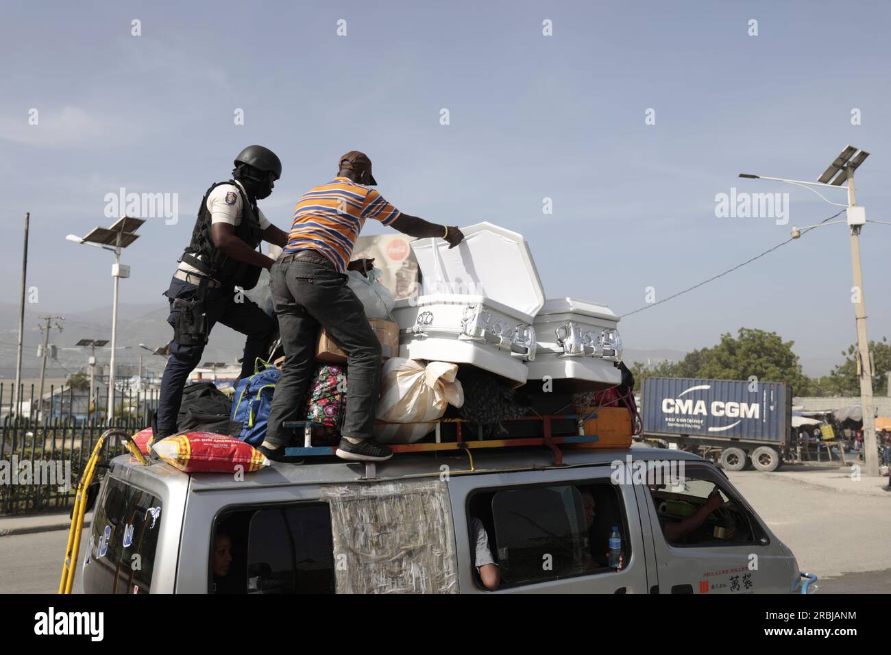 A policeman checks a public transport driver's cargo that includes ...