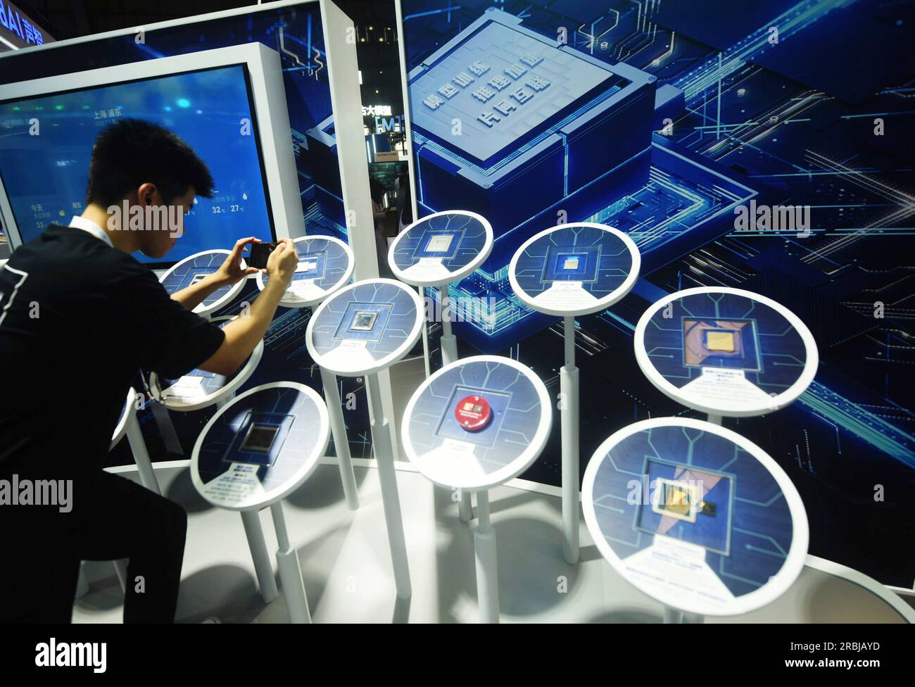 A visitor takes photos of AI chips exhibited by Unitree Robotics at the ...