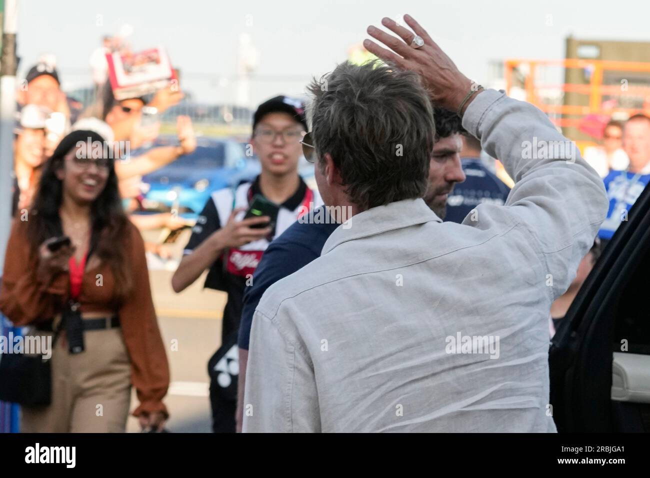 Actor Brad Pitt cheers fans leaving the paddock after after the second ...