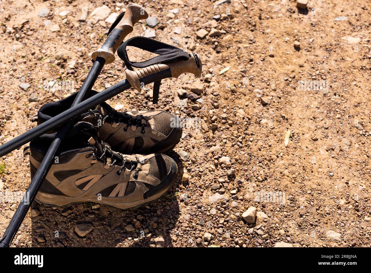 Hiking poles and shoes on ground on sunny day Stock Photo - Alamy