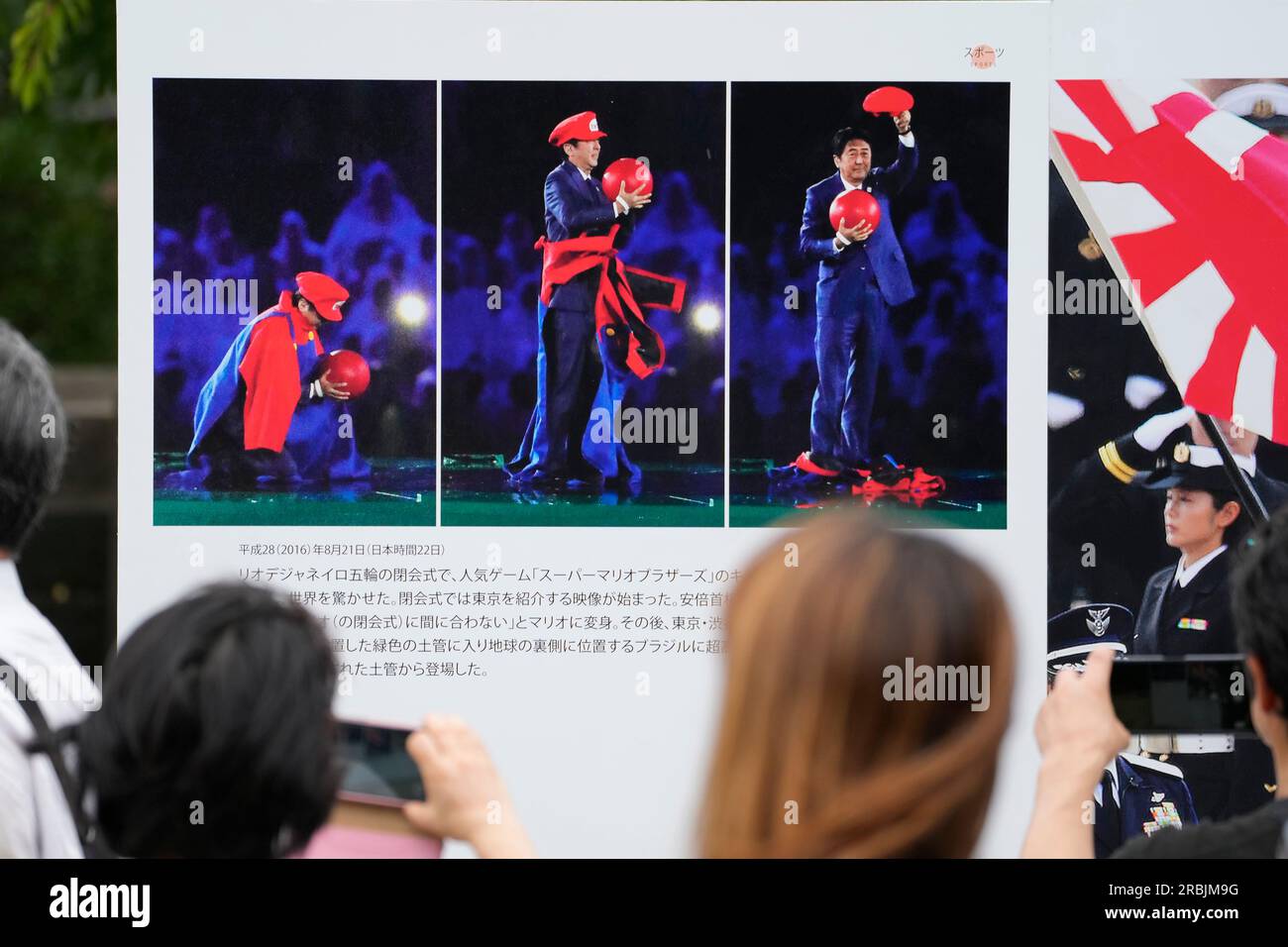 People watch the images of Japan's former Prime Minister Shinzo Abe ...