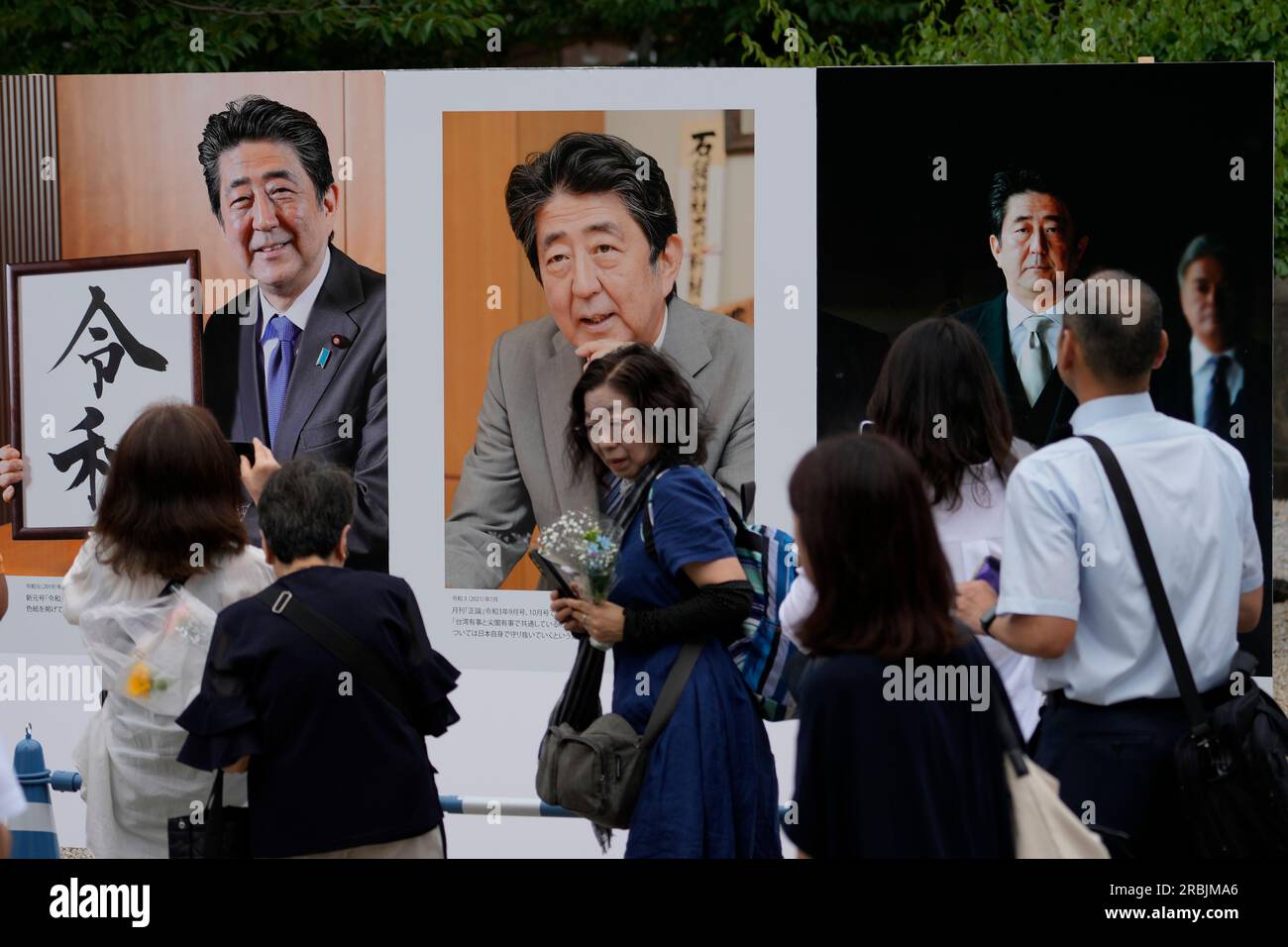 People watch the images of Japan's former Prime Minister Shinzo Abe ...