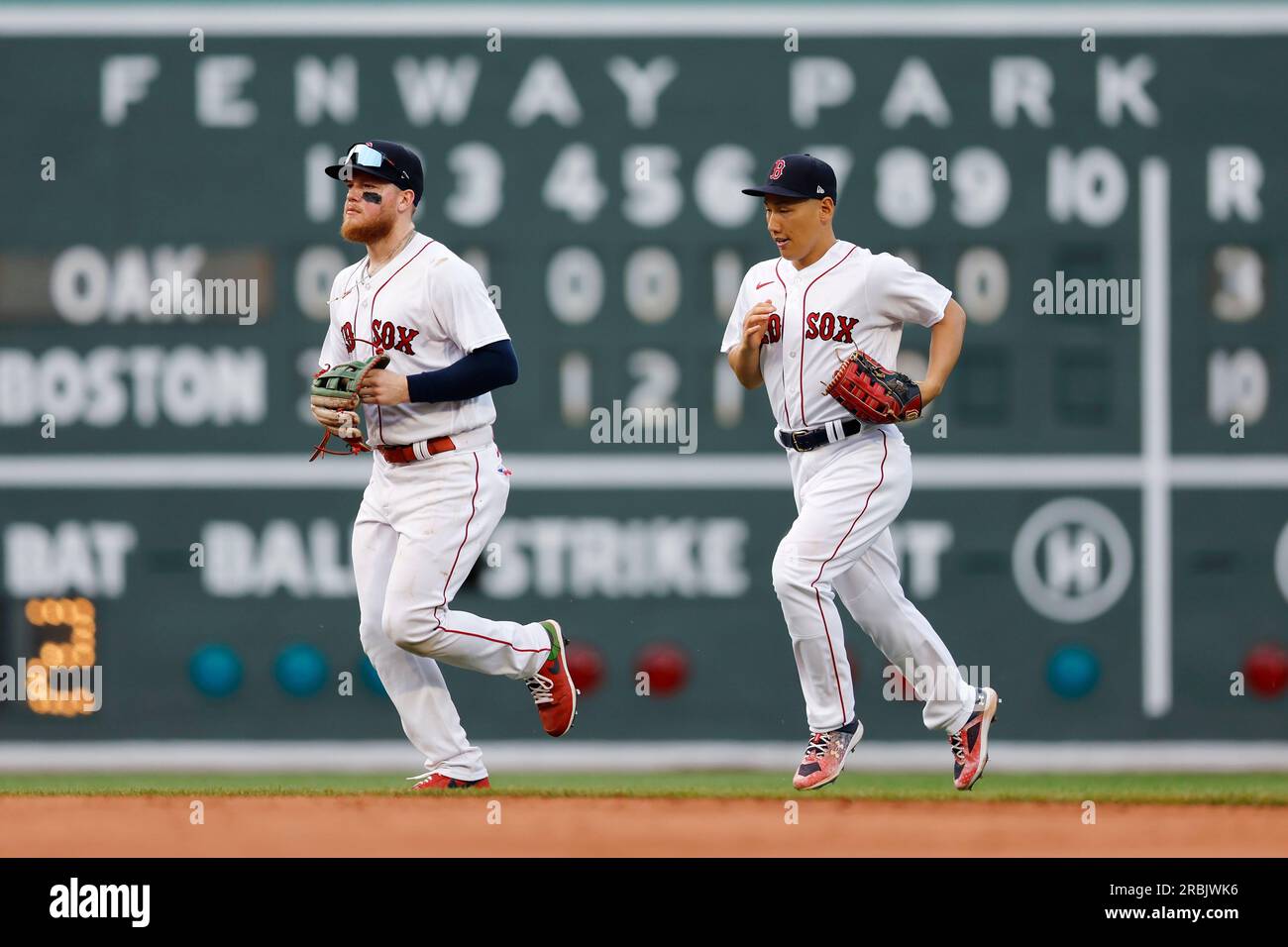 Boston Red Sox's Alex Verdugo, left, and Masataka Yoshida jog past the scoreboard after ...
