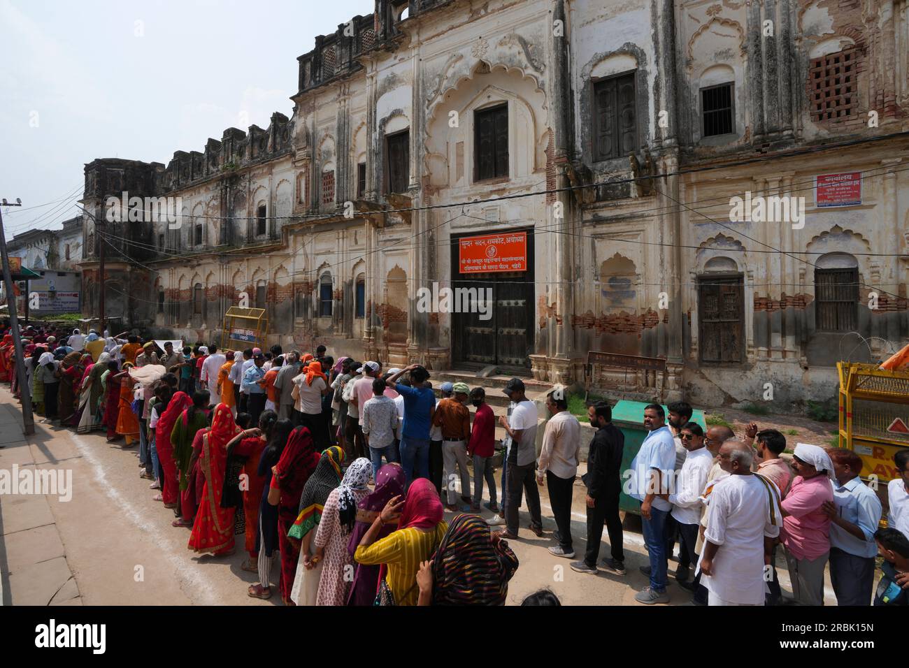 Hindu devotees stand in queue to offers prayers at a makeshift temple ...
