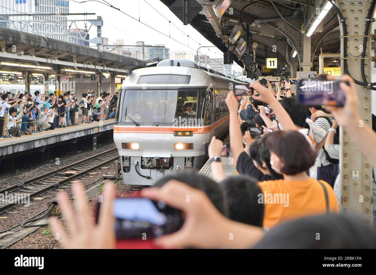 A crowd of trainspotters takes photos of the Kiha 85 series train ...