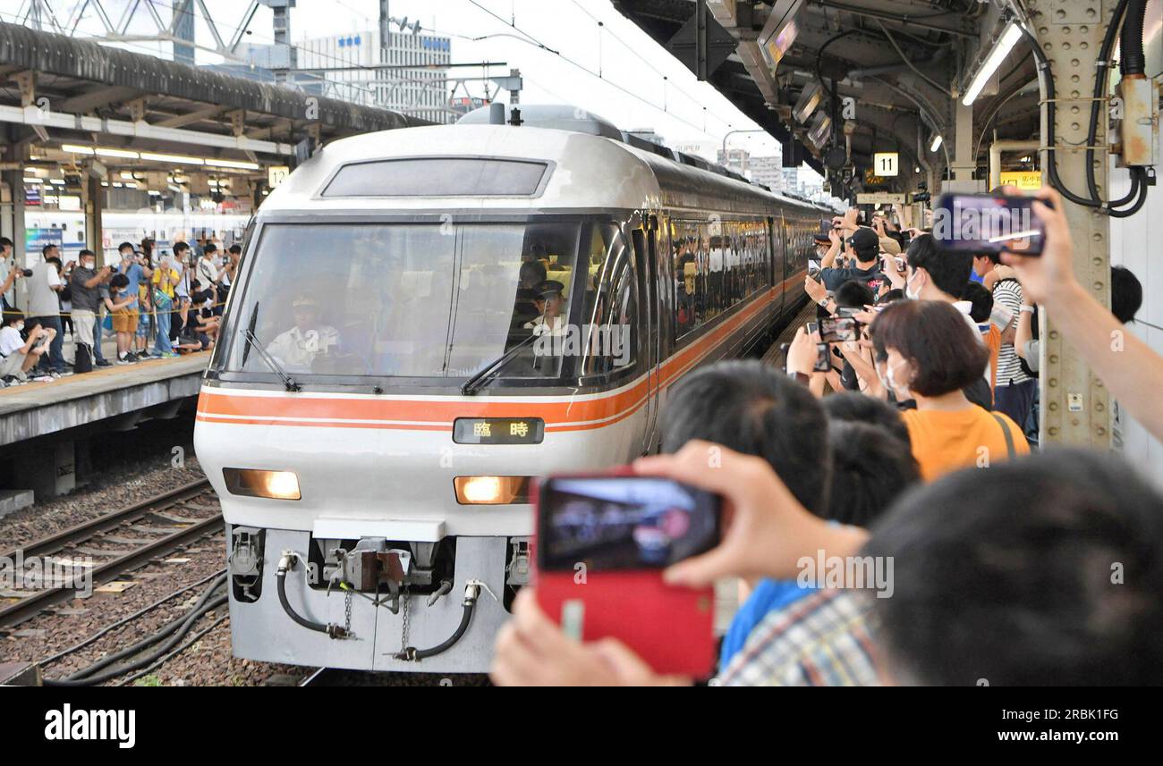 A crowd of trainspotters takes photos of the Kiha 85 series train ...