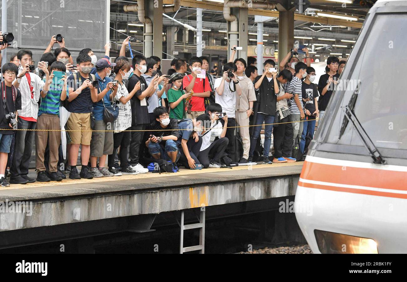 A crowd of trainspotters takes photos of the Kiha 85 series train ...
