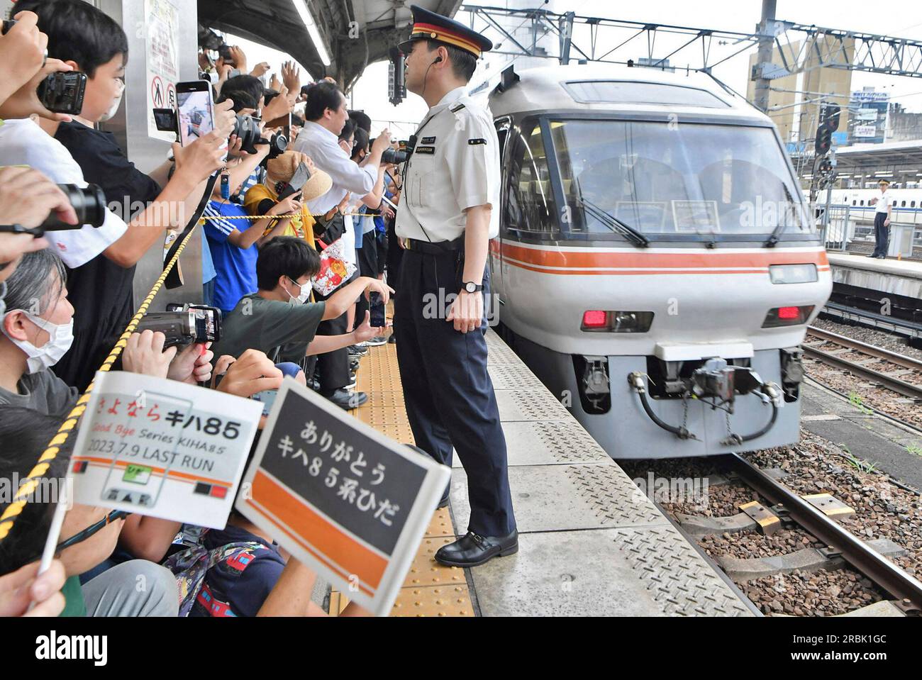 A crowd of trainspotters takes photos of the Kiha 85 series train ...