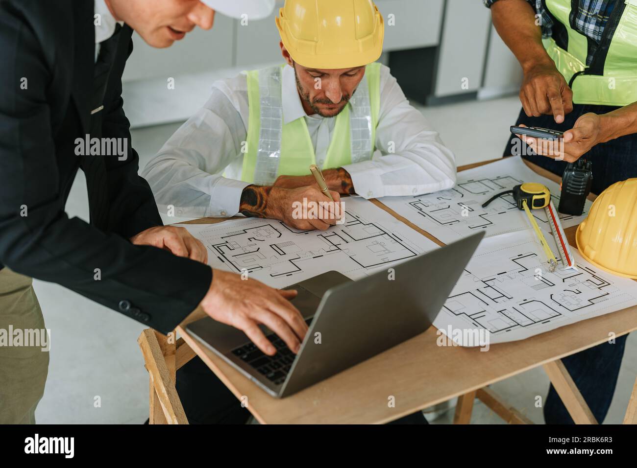 multi ethnic engineer brainstorming and measuring for cost estimating ...