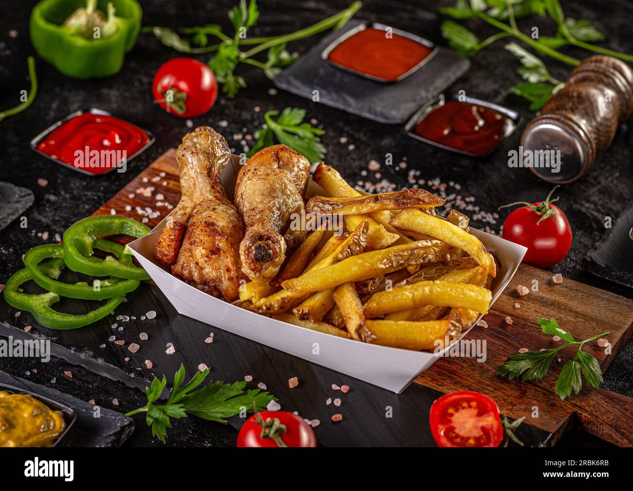 Grilled chicken legs with potato chips, still life Stock Photo - Alamy