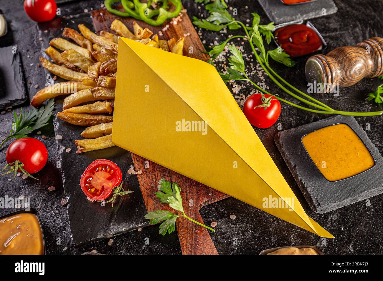 Still life of French fries in a paper wrapper Stock Photo - Alamy