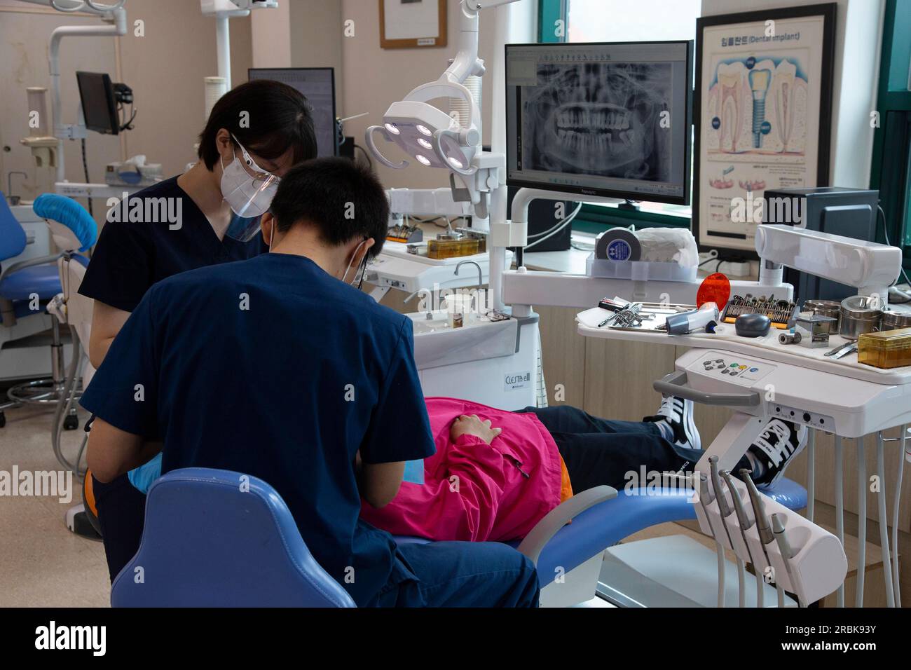 A North Korean defector, red shirt, receives teeth care at a dentist's ...