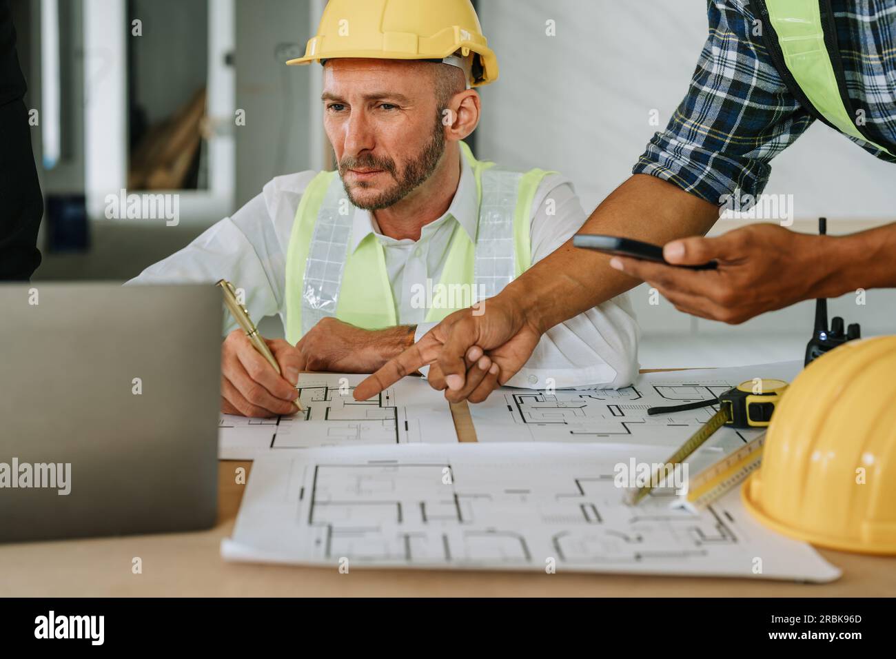 multi ethnic engineer brainstorming and measuring for cost estimating ...