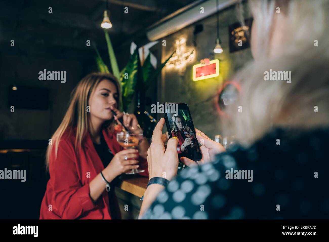 Two Girlfriends Taking A Photo In A Cocktail Bar Stock Photo - Alamy
