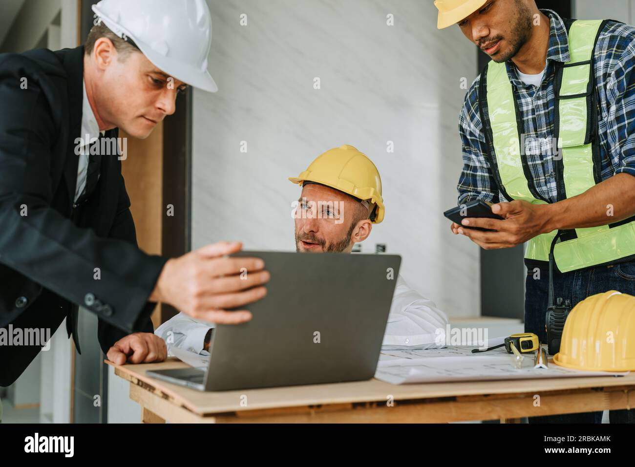 multi ethnic engineer brainstorming and measuring for cost estimating ...