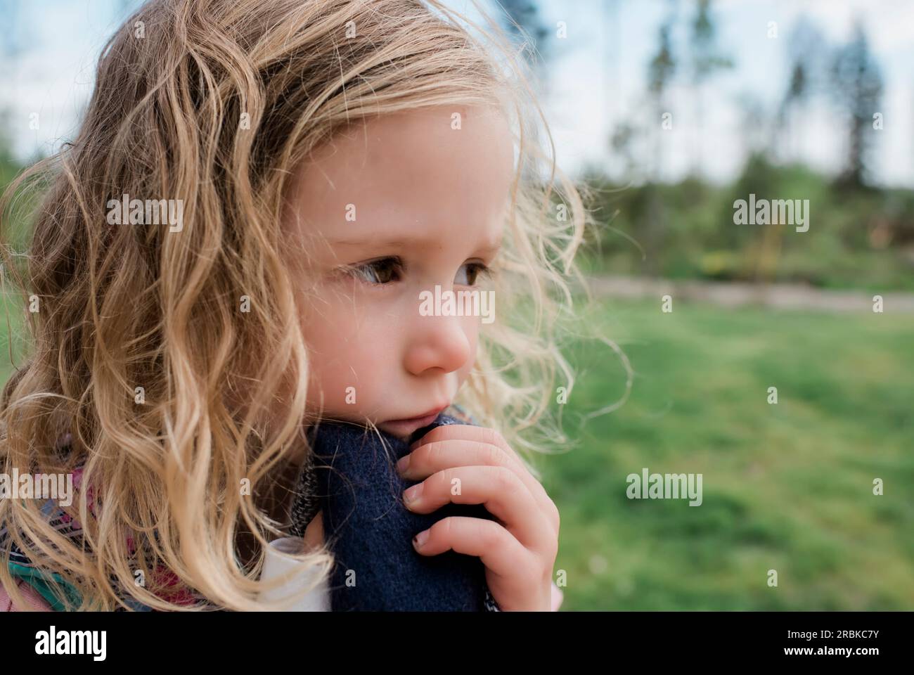 portrait of a girl thinking whilst playing outside Stock Photo - Alamy