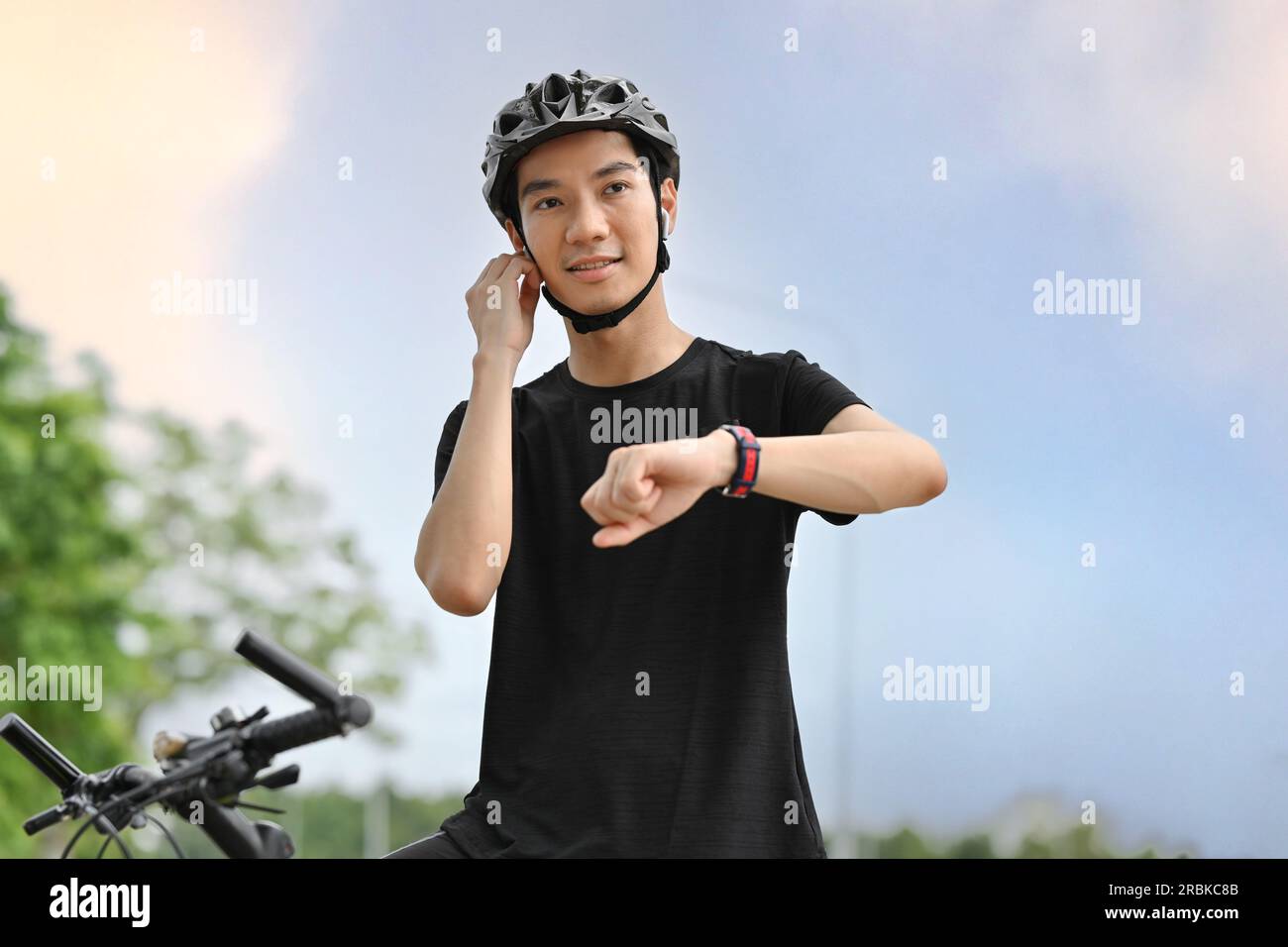 Low angle of asian man cyclist checking his workout progress on a smart ...