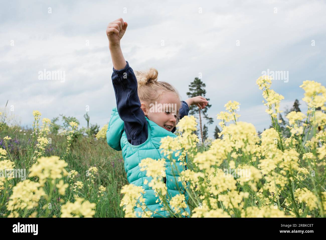 young girl jumping and laughing in a field of flowers Stock Photo - Alamy