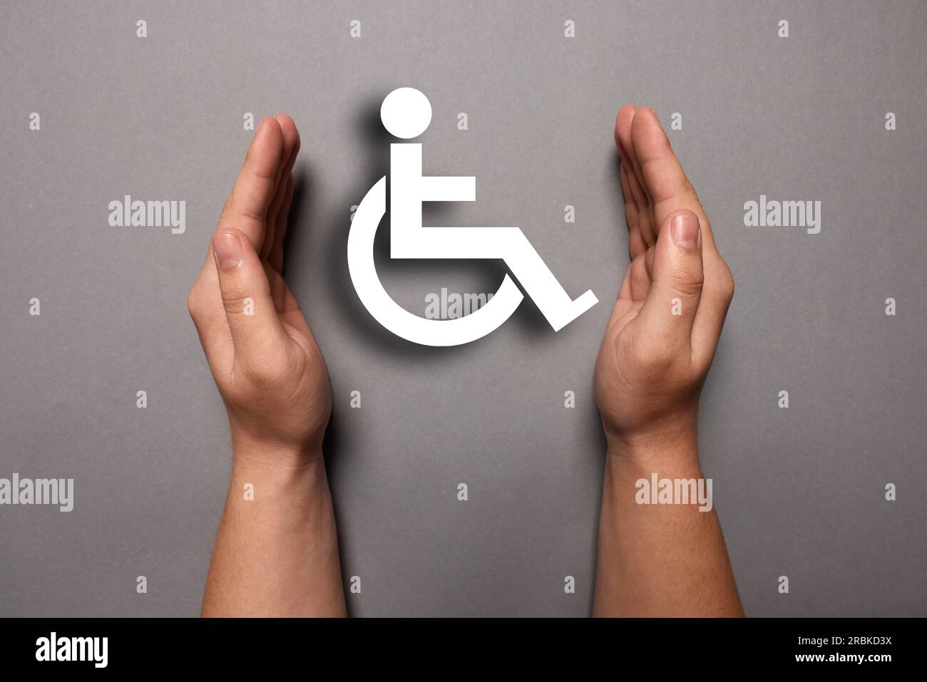 Disability inclusion. Woman protecting wheelchair symbol on grey ...