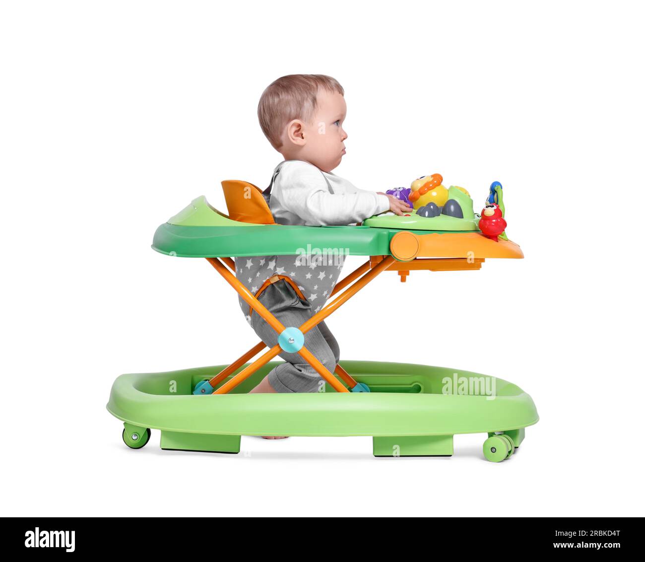 Cute little boy making first steps with baby walker on white background ...