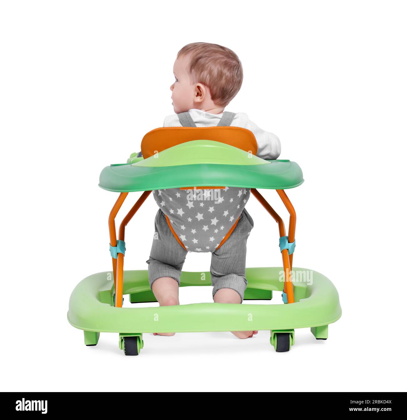 Cute little boy making first steps with baby walker on white background ...