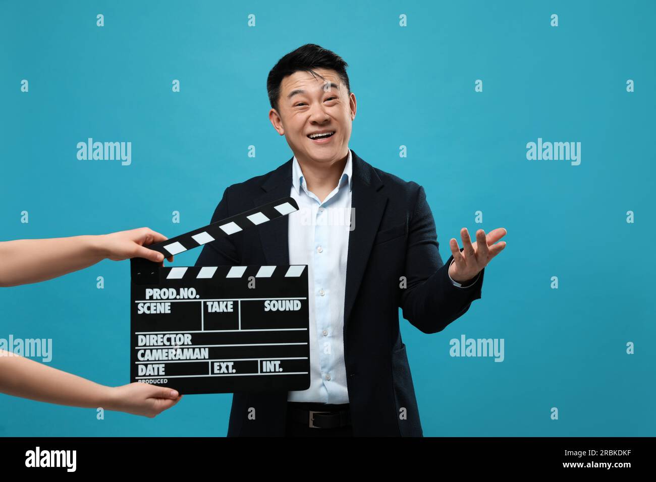 Happy asian actor performing while second assistant camera holding ...