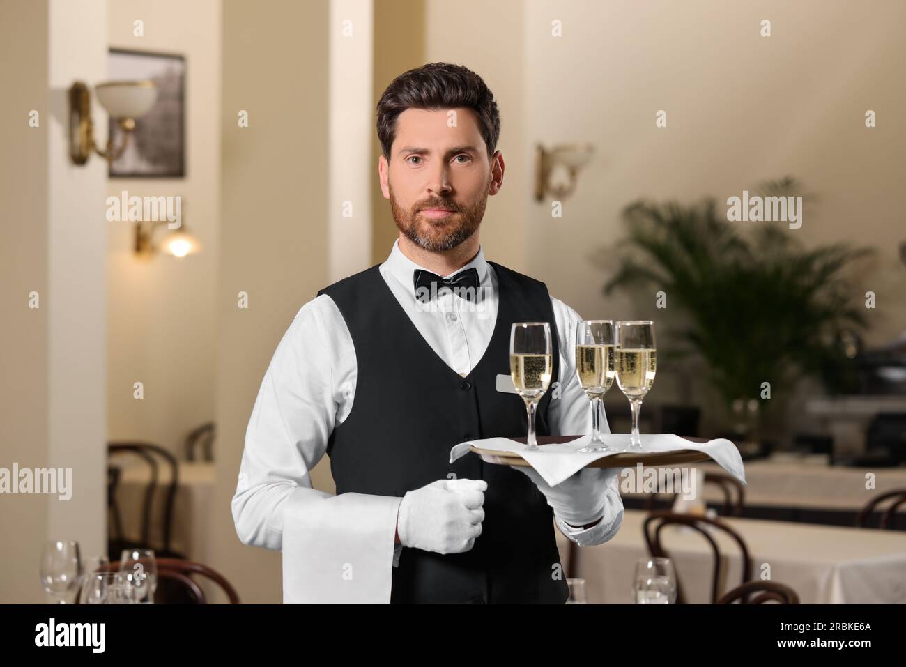 Butler holding tray with glasses of sparkling wine in restaurant Stock ...