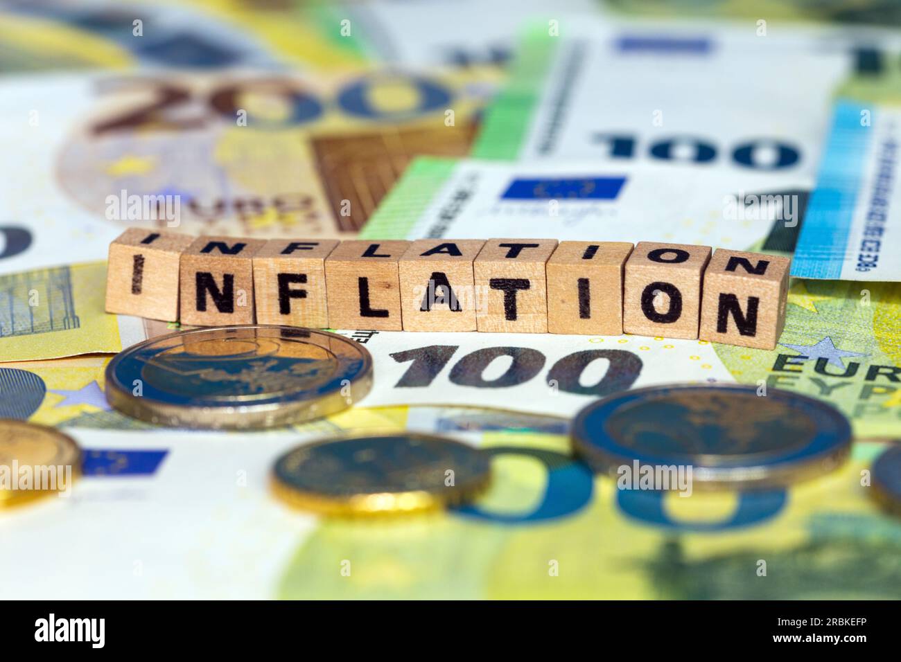 Symbol image of inflation: Euro banknotes, euro coins and letter cubes ...