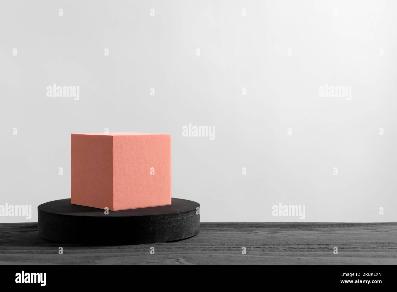 Cube and round shaped podiums on grey wooden table. Space for text ...