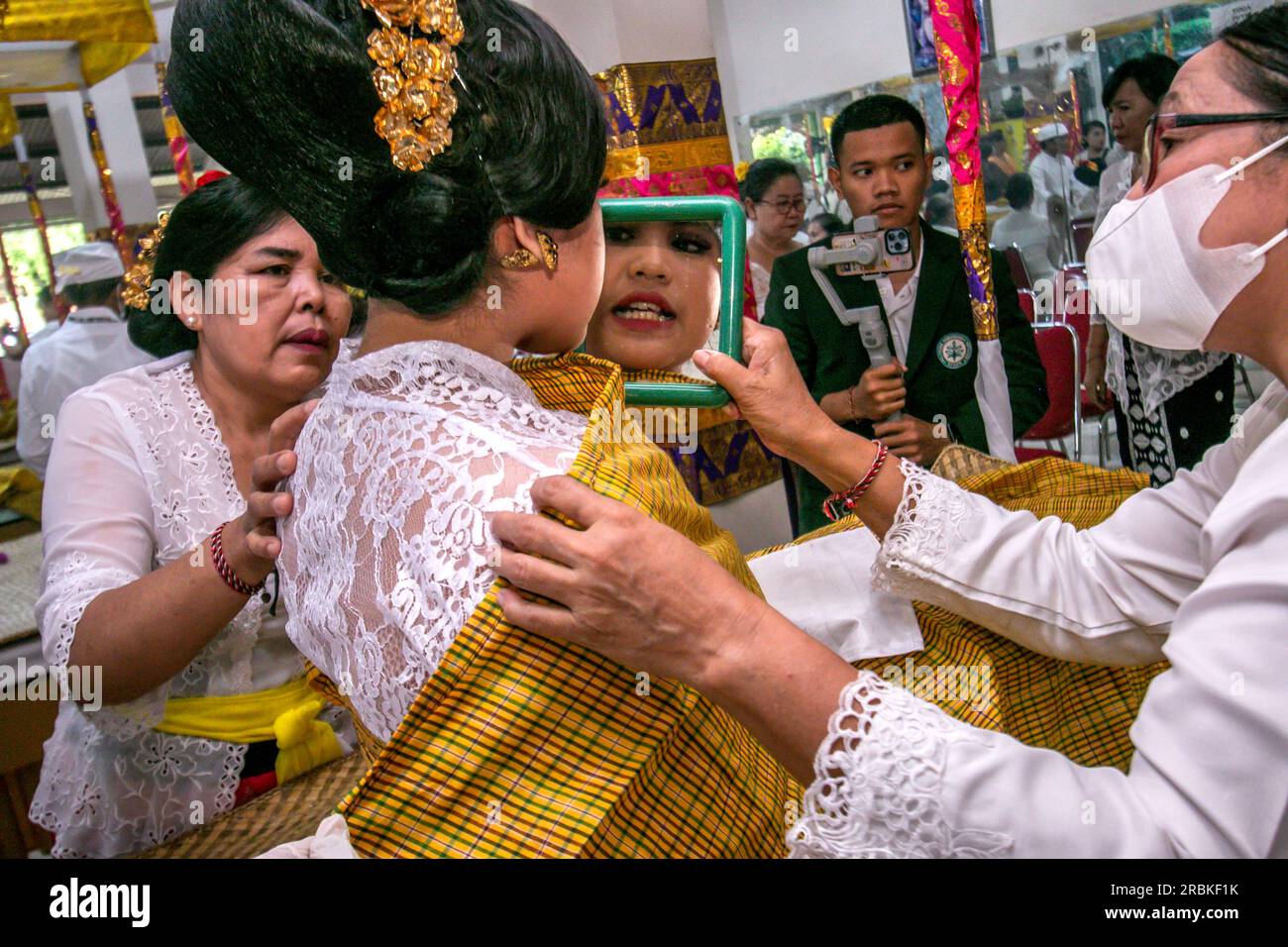 A participant looks at his teeth through a mirror at the Giri Kusuma ...