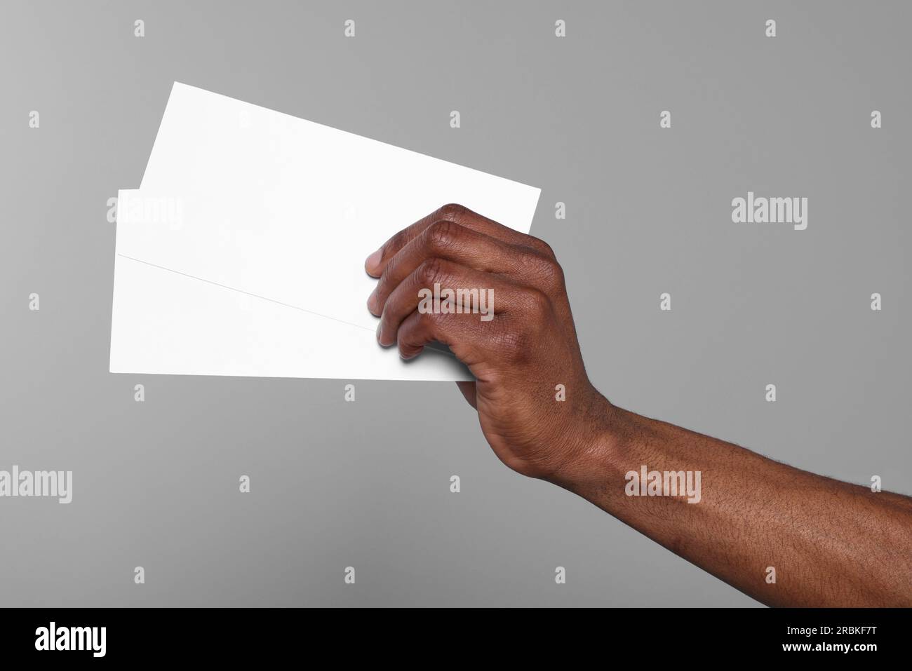 African American man holding flyers on grey background, closeup. Mockup ...