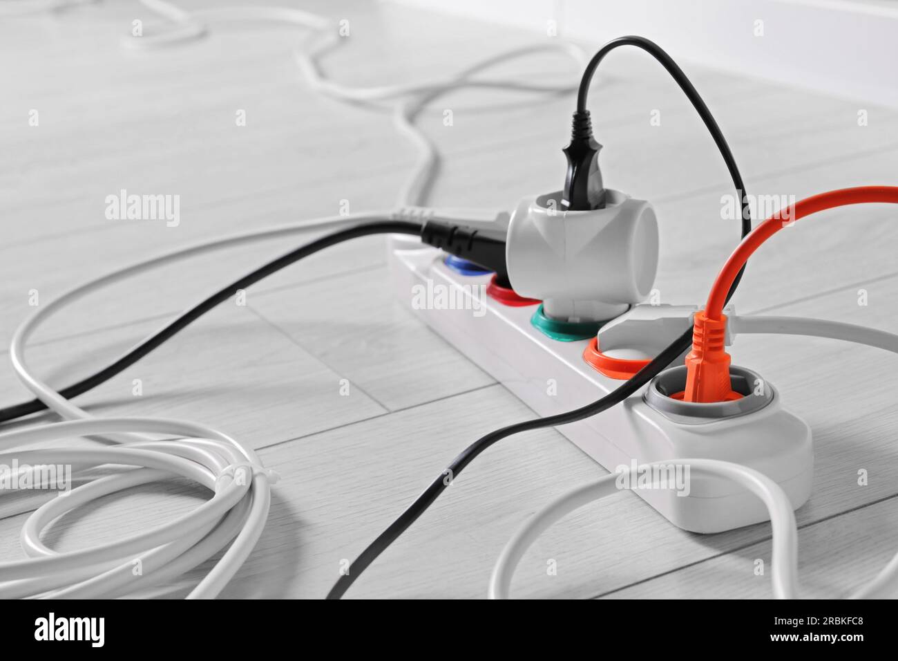 Power strip with different electrical plugs on white laminated floor ...