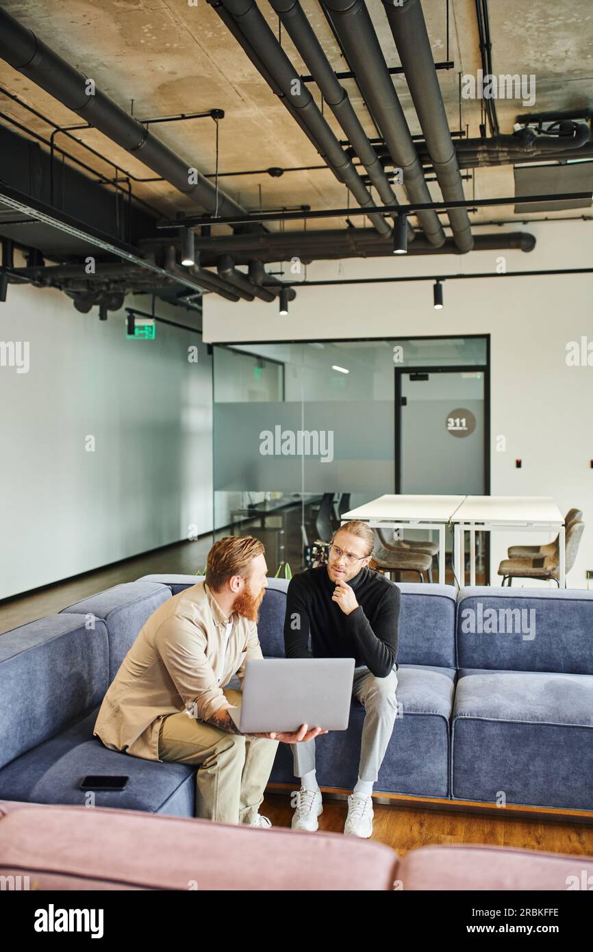 stylish business partners discussing startup project while sitting on ...