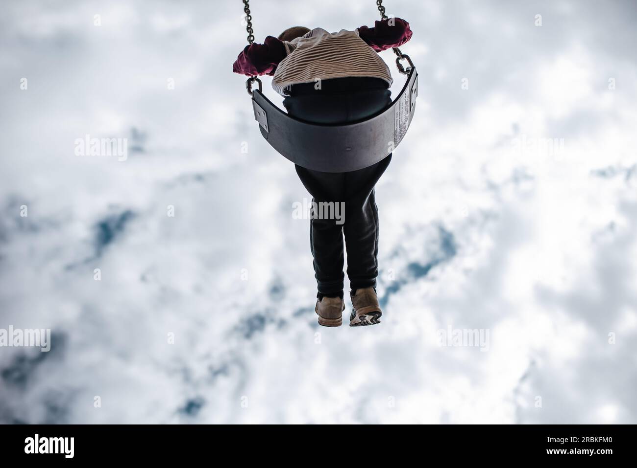 Wide shot of 5 year old boy swinging high on a swing Stock Photo - Alamy