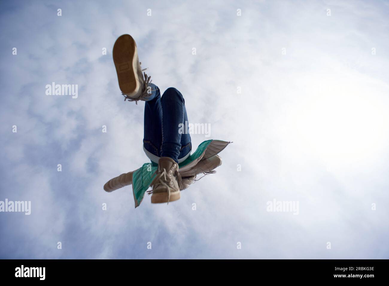Young girl jumping high into the sky, shot from underneath Stock Photo ...